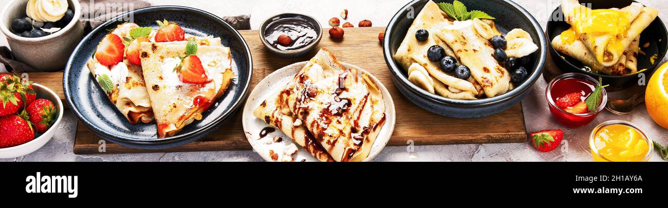 Sweet crepes assortment with berries chocolate on gray background ...