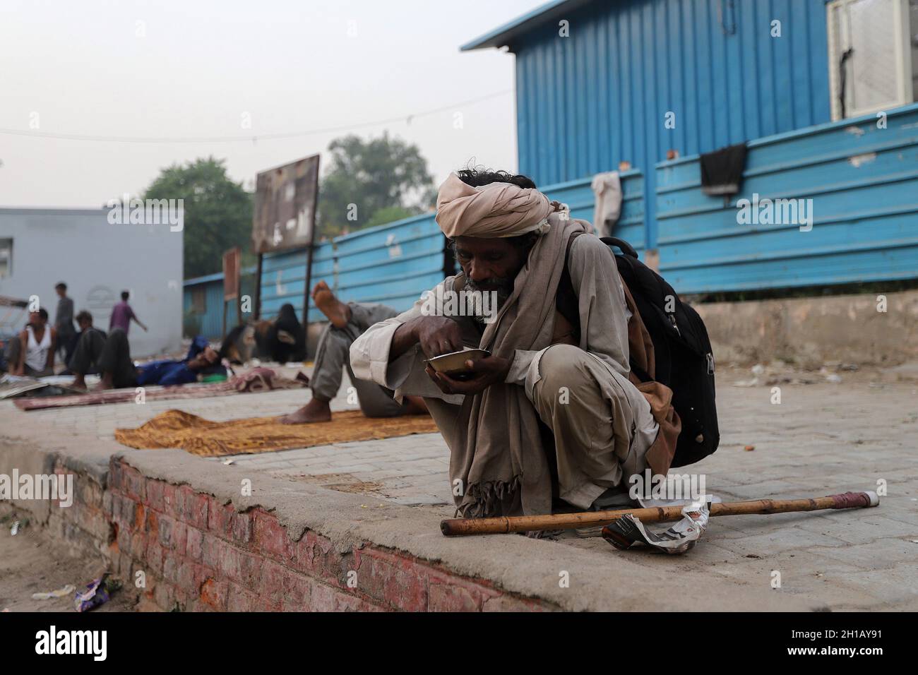 A homeless man eats food being distributed by volunteers along the ...