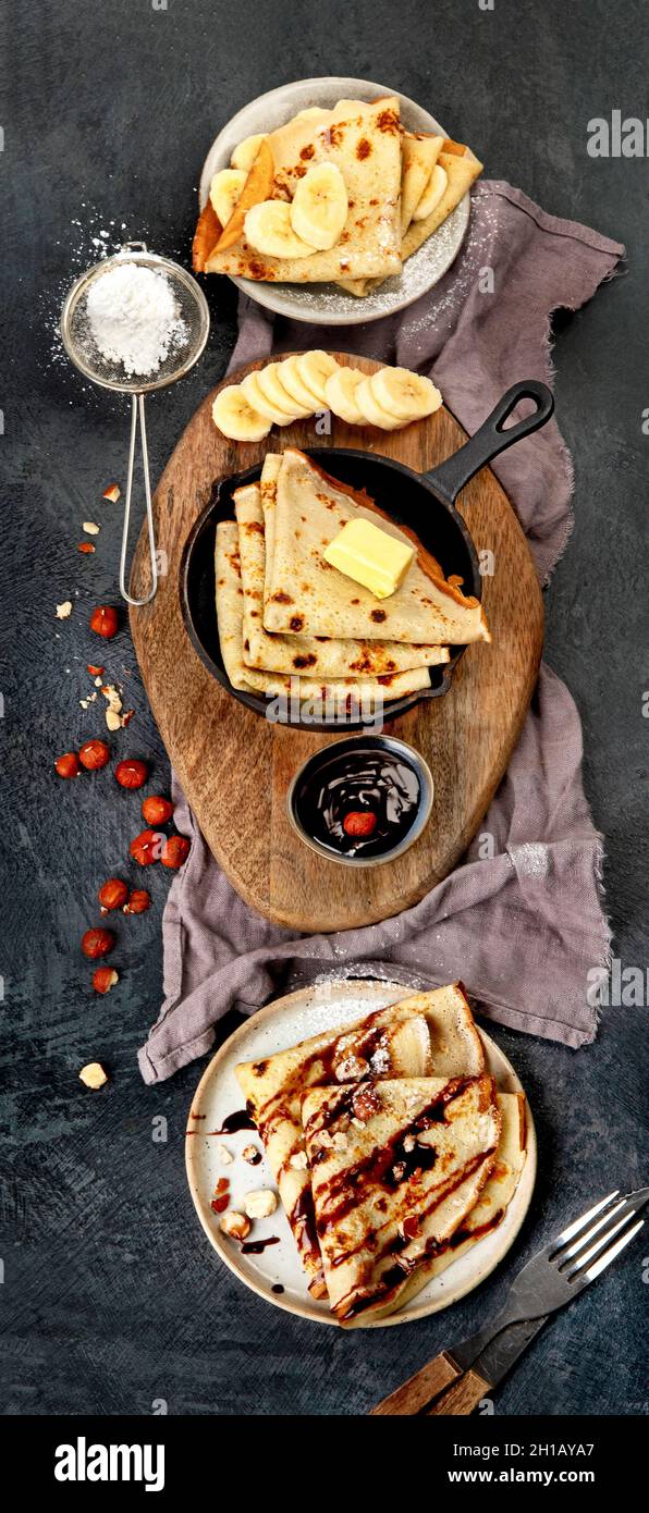 Crepes with sweet toppings on dark background. Homemade food concept ...