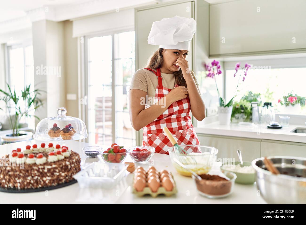 Beautiful young brunette pastry chef woman cooking pastries at the ...