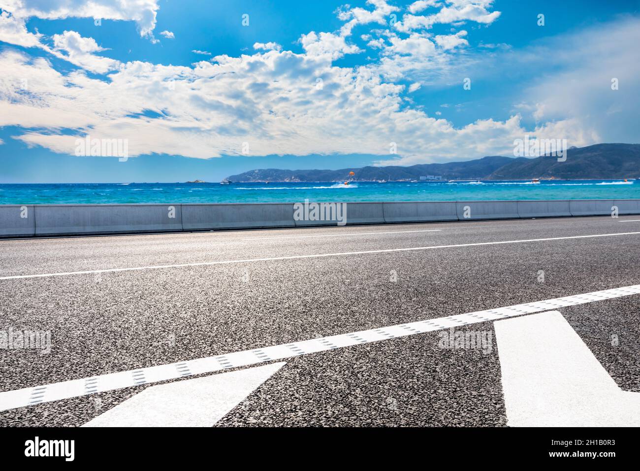 Wide asphalt road by the blue sea Stock Photo - Alamy