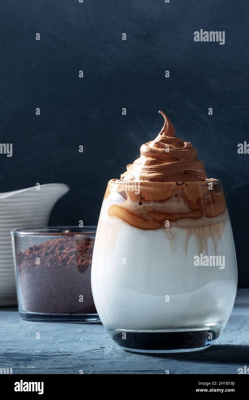 Dalgona cold coffee in a glass on a dark blue background with a place ...