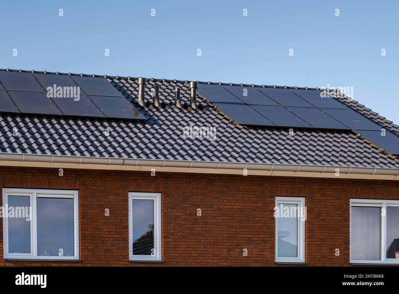 Newly build houses with solar panels attached on the roof against a ...