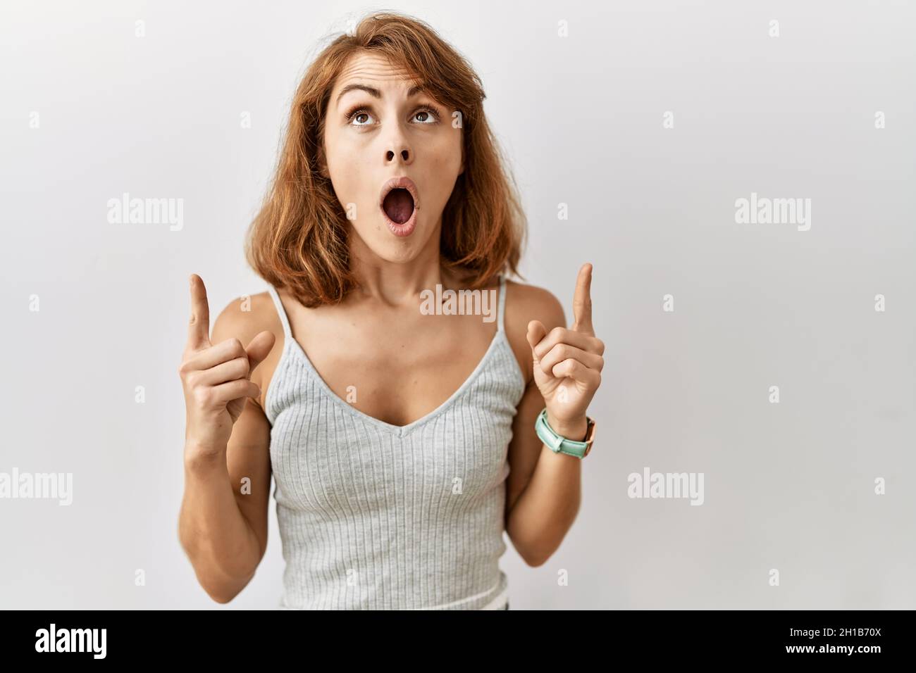 Beautiful caucasian woman standing over isolated background amazed and ...