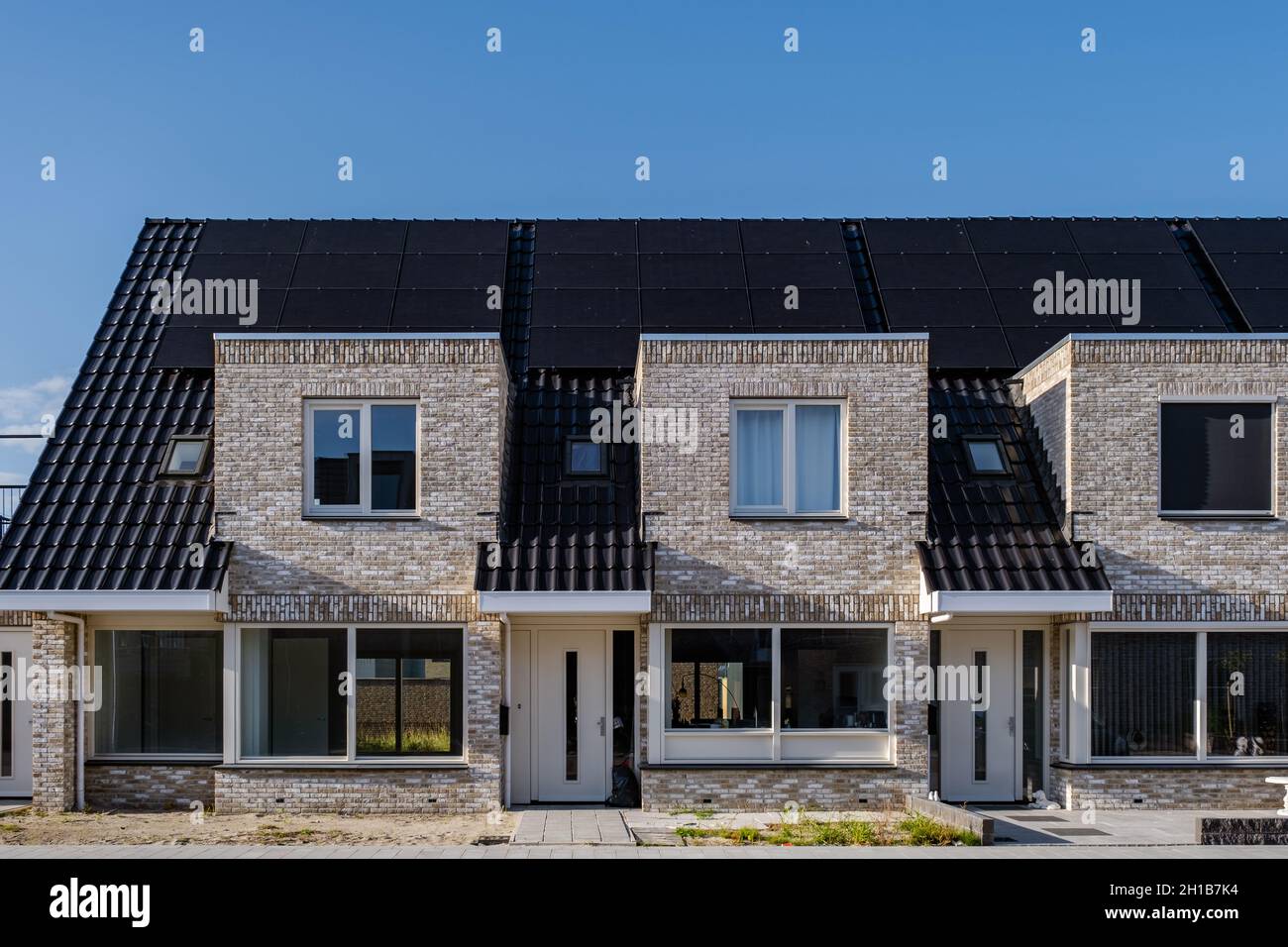 Newly build houses with solar panels attached on the roof against a ...