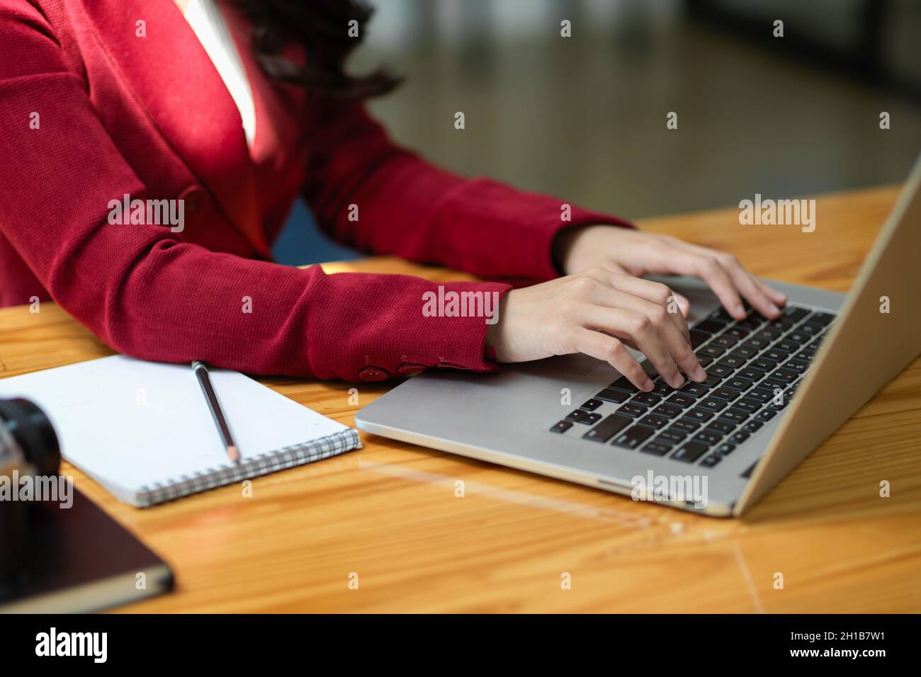 An elegant young businesswoman works on her laptop computer, typing on ...