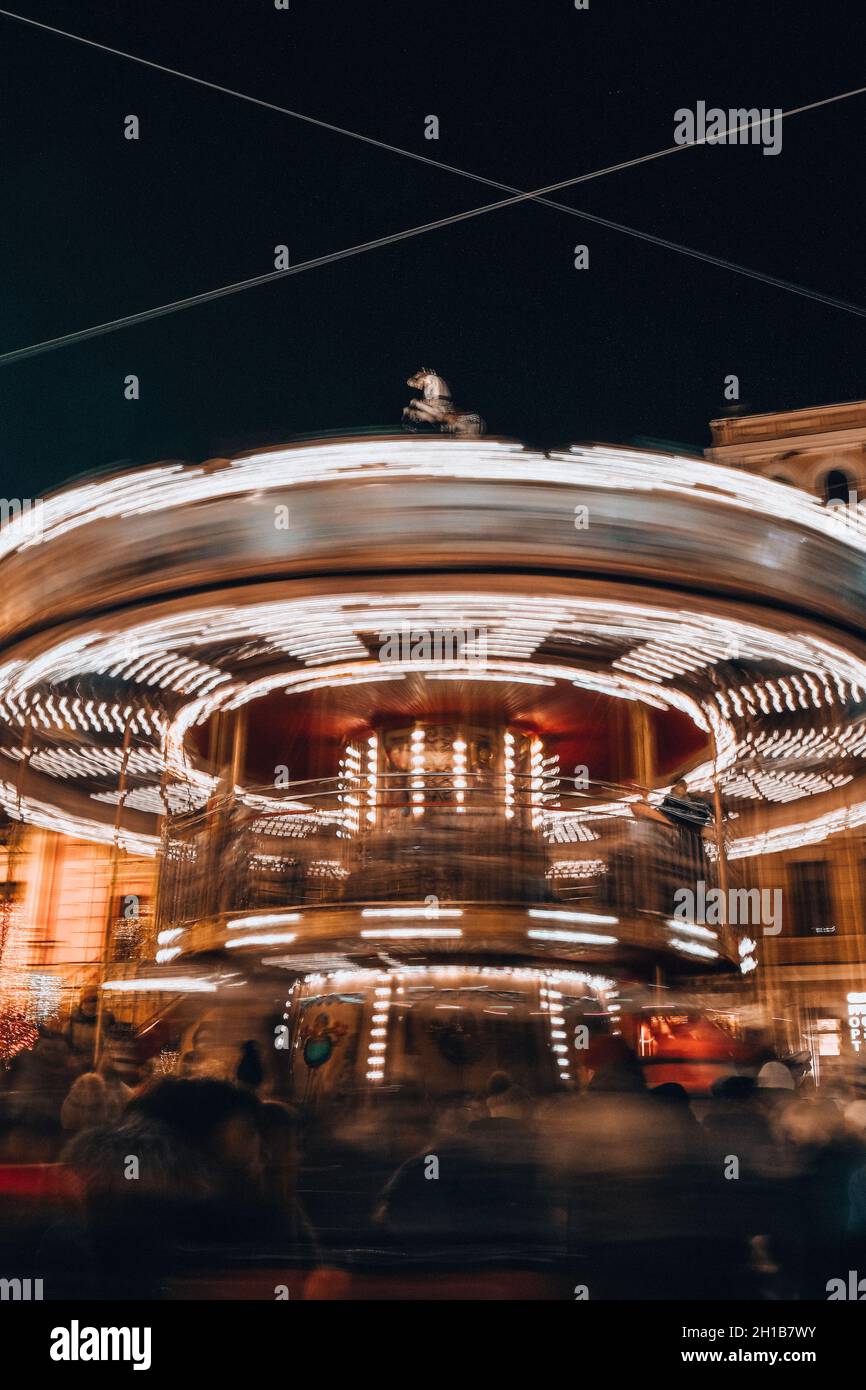 Children's Carousel in the evening and night illumination. Spinning ...