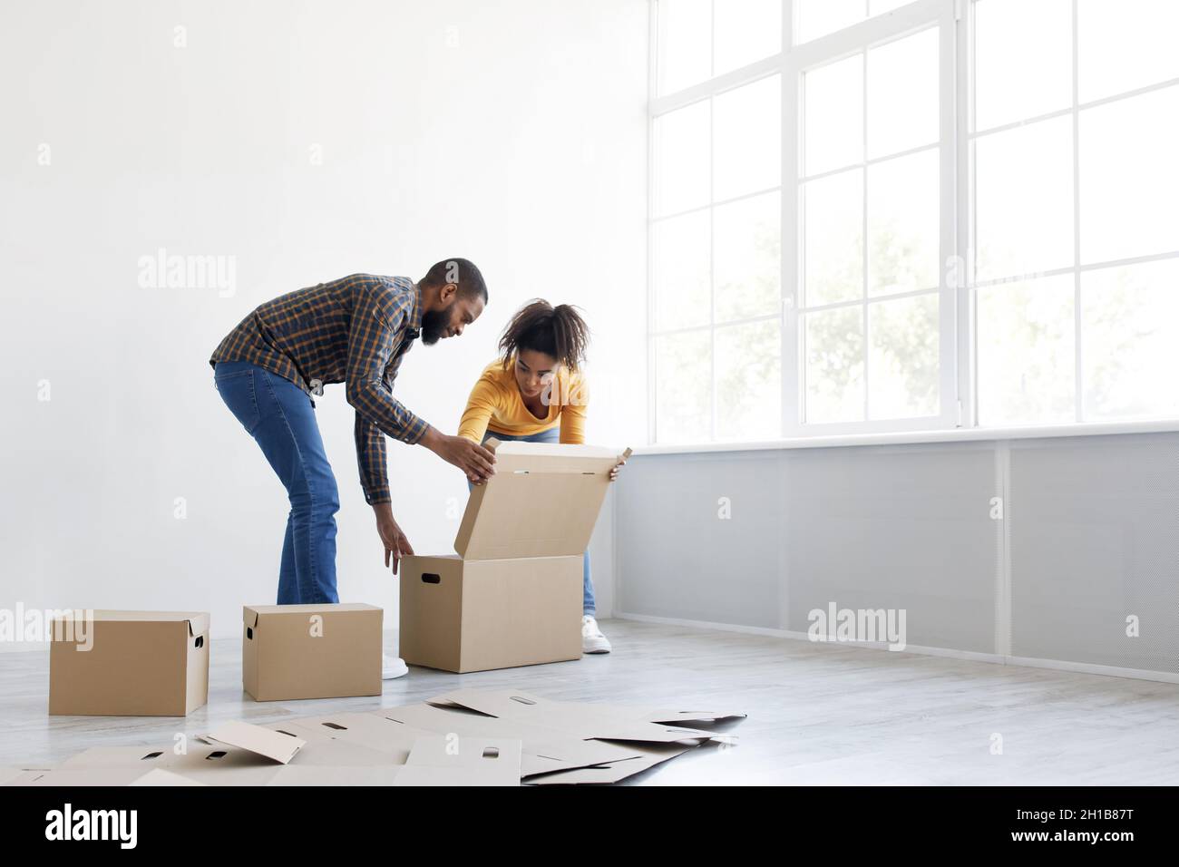 Millennial african american husband helps wife get ready to move with ...