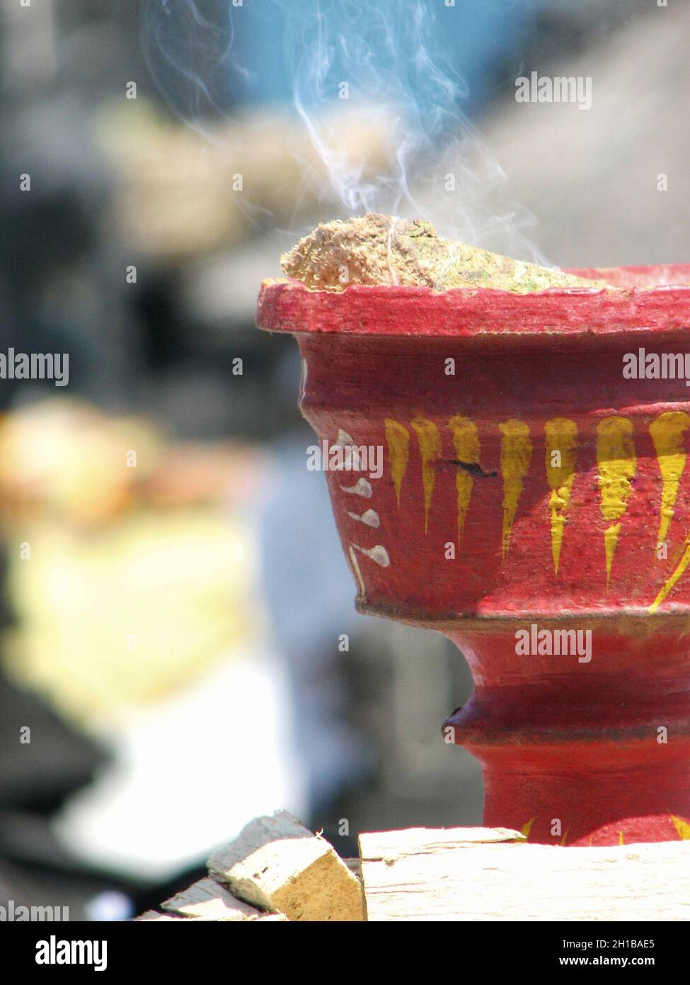 Close up of red pot incense burner with smoke in Balinese Hindu ritual ...