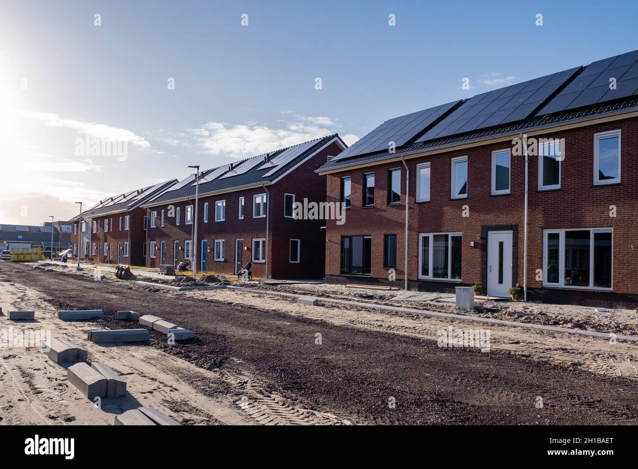Newly build houses with solar panels attached on the roof against a ...