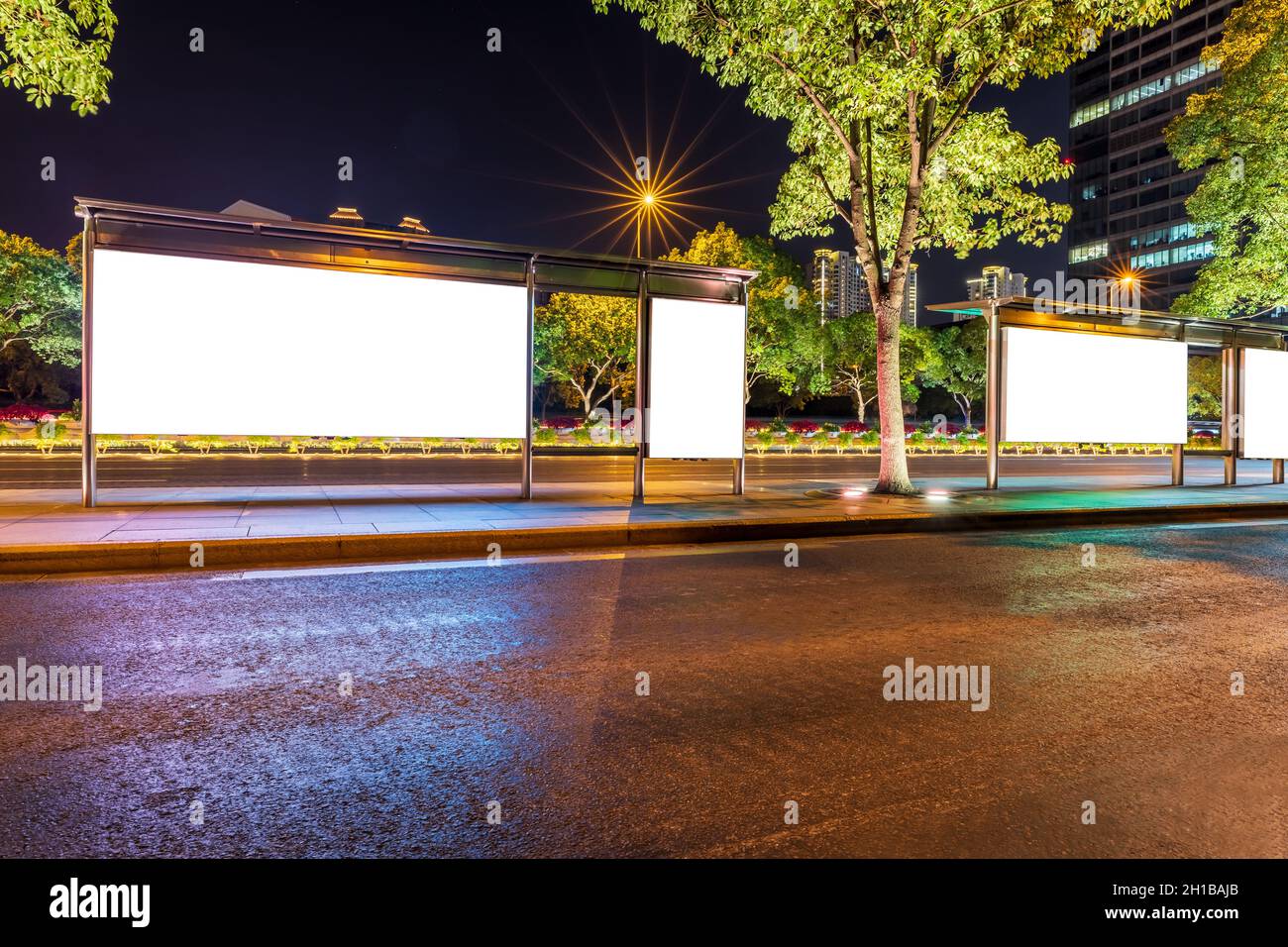 Night shot of a luminous advertising lightbox or display at a bus stop ...