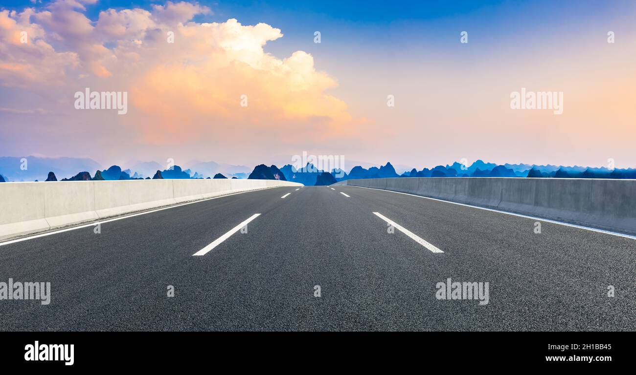 Asphalt highway and mountain landscape at sunset,road pavement ...