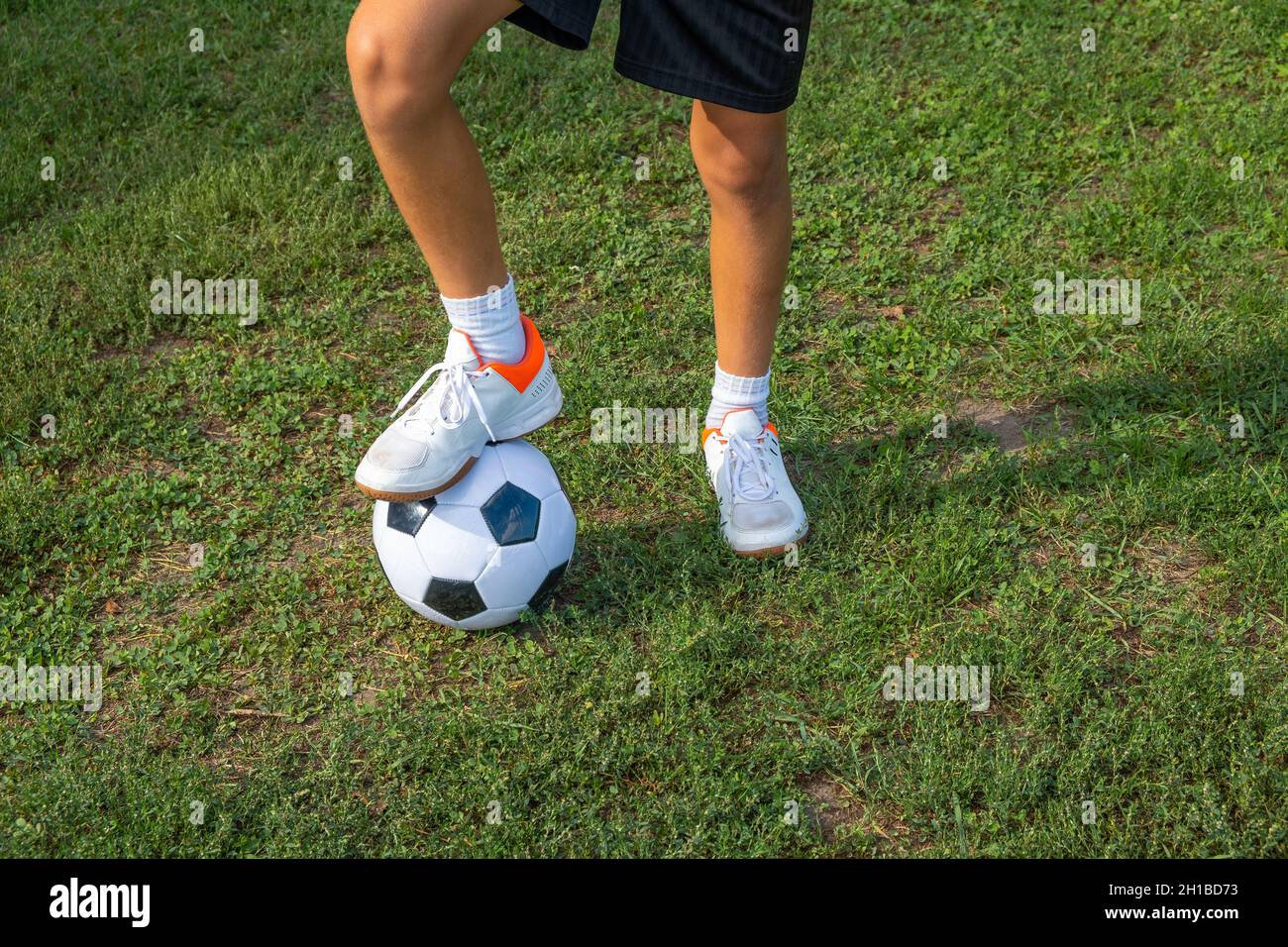 Boy teen puts his leg on ball on soccer field. Training, active ...