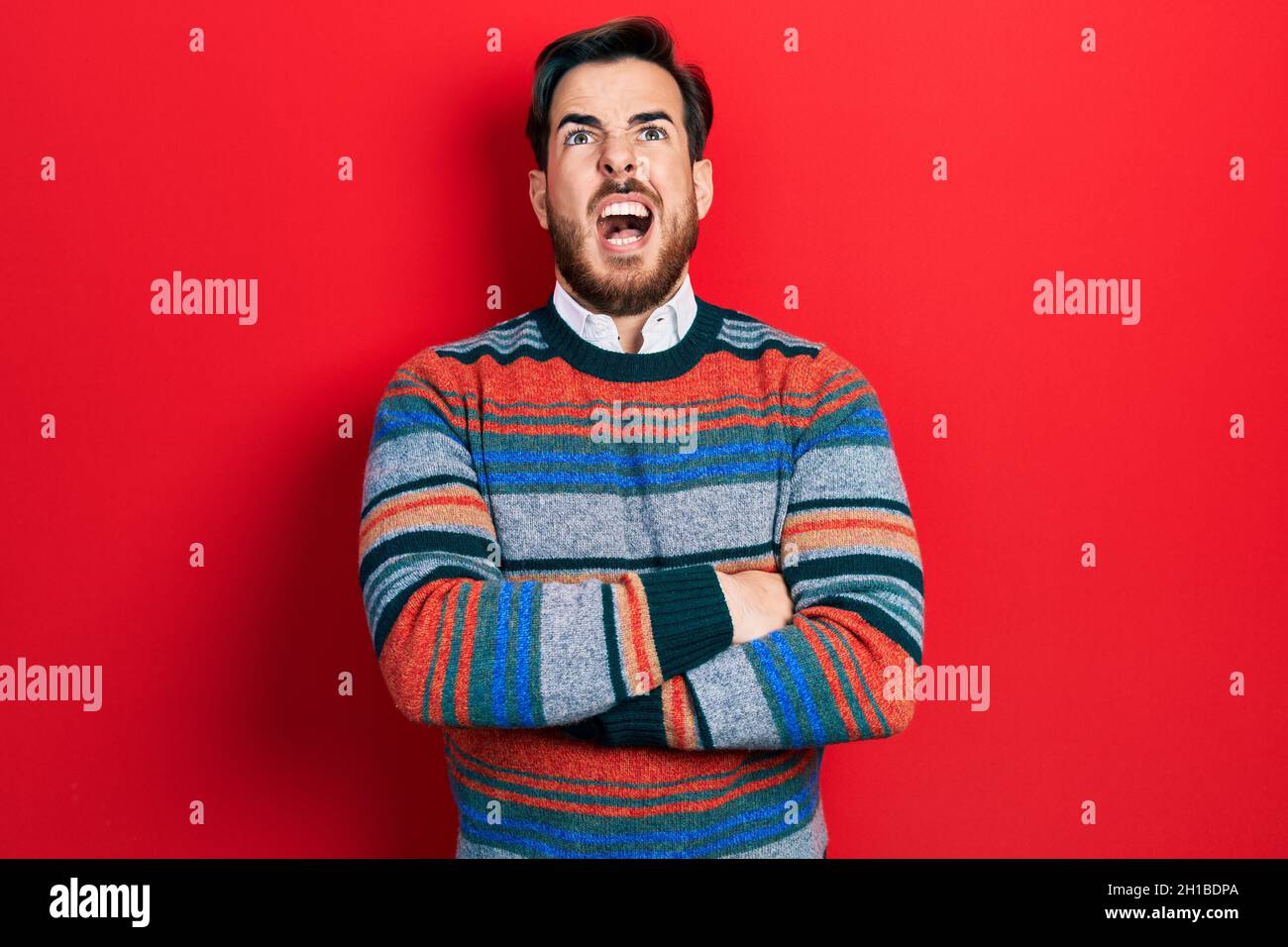 Handsome caucasian man with beard with arms crossed gesture angry and ...