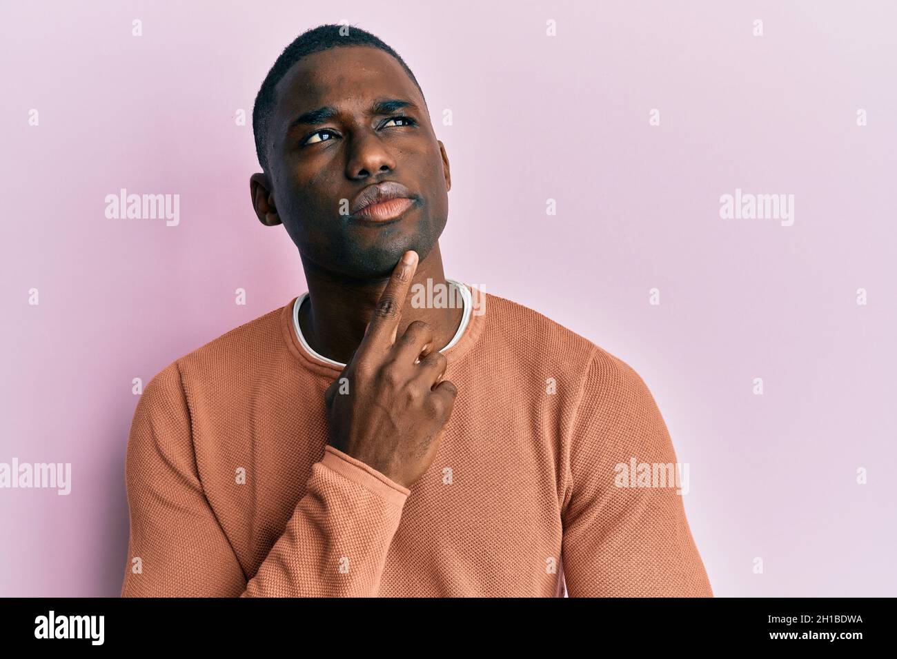 Young african american man wearing casual clothes with hand on chin ...