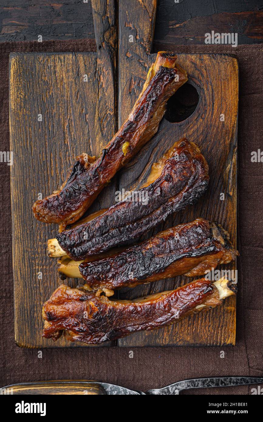 Spicy hot grilled spare ribs from a summer BBQ set, on wooden serving ...