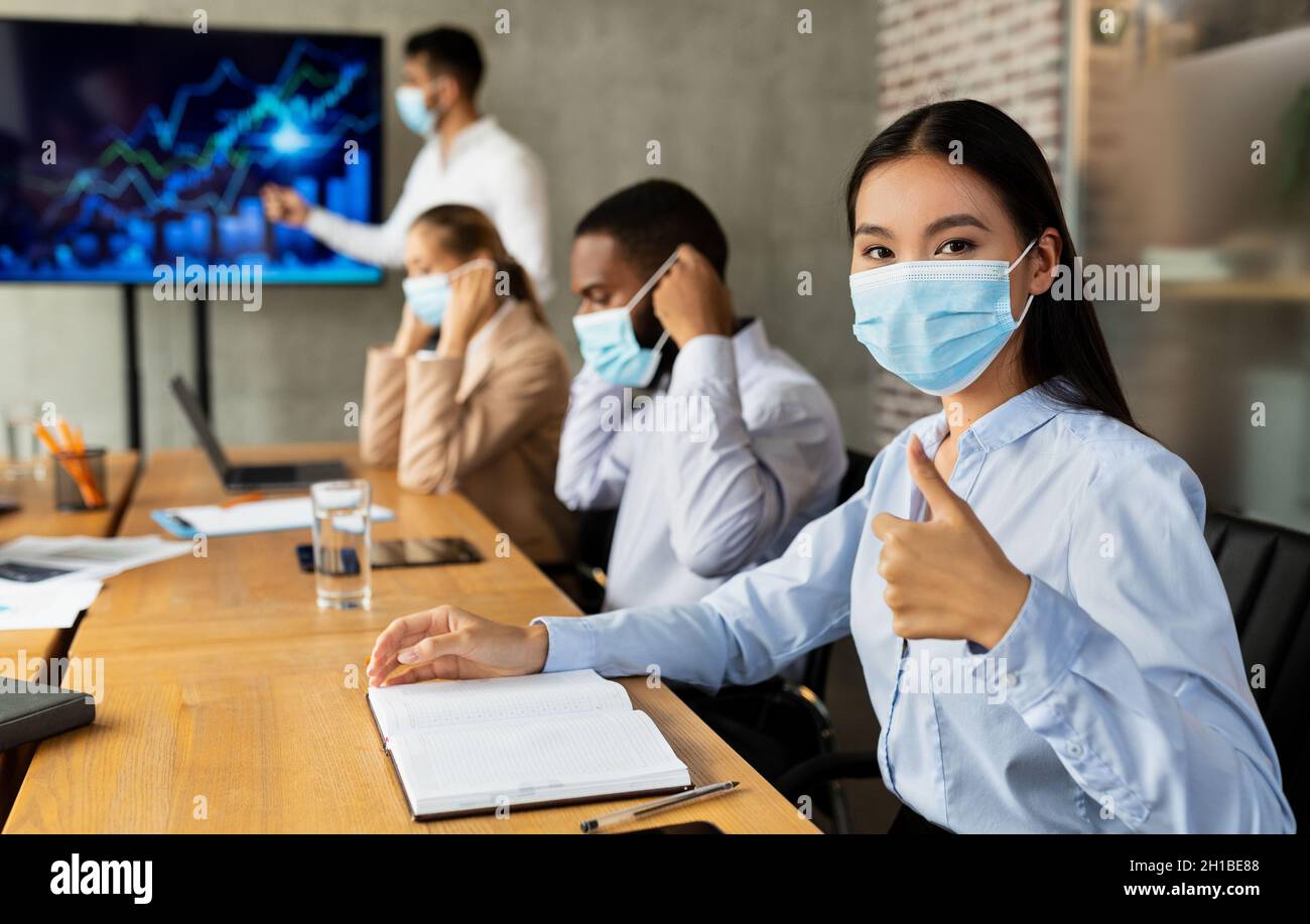 New Normal At Work. Business People Wearing Medical Masks At Corporate ...