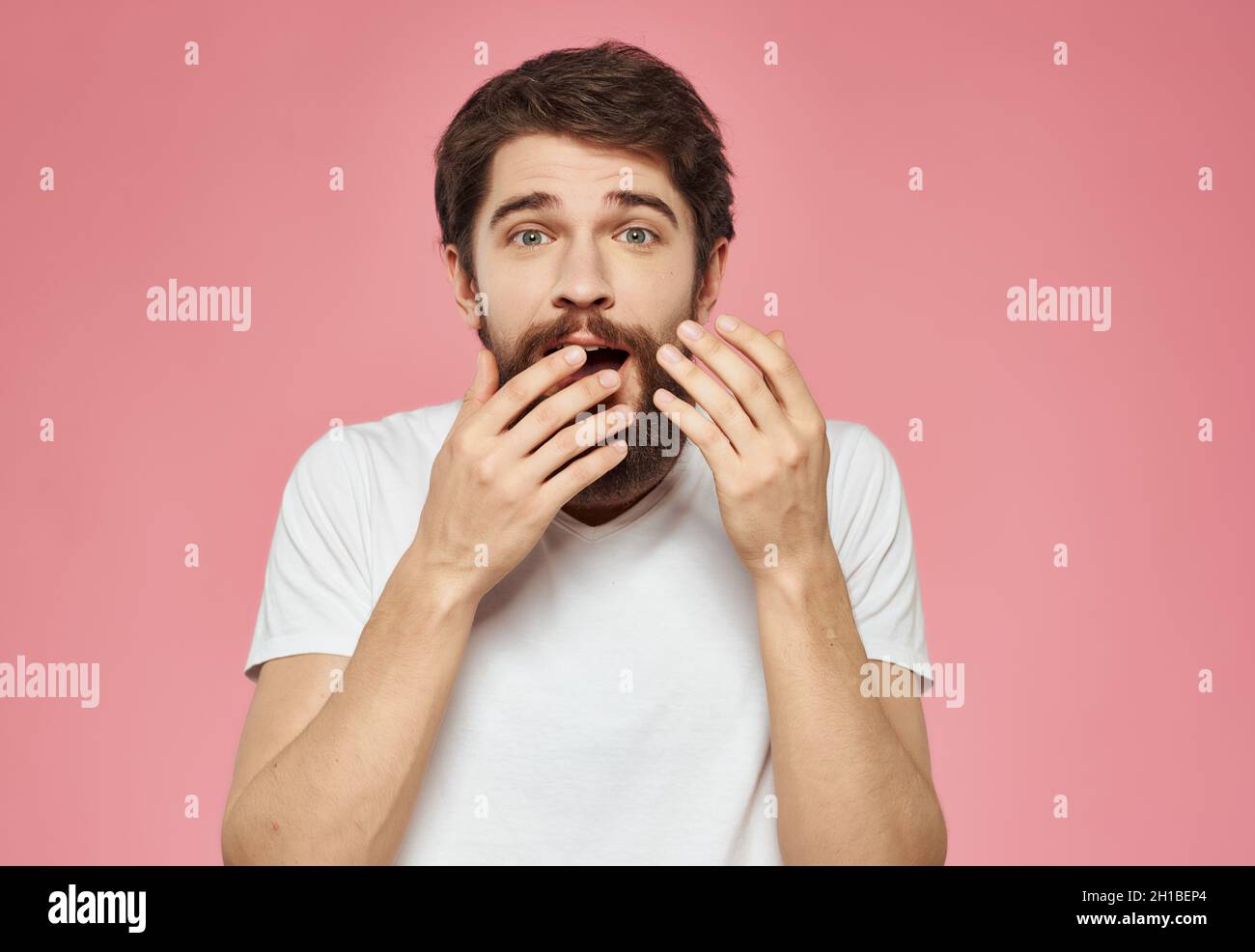 emotional man in a white t-shirt irritated facial expression pink ...