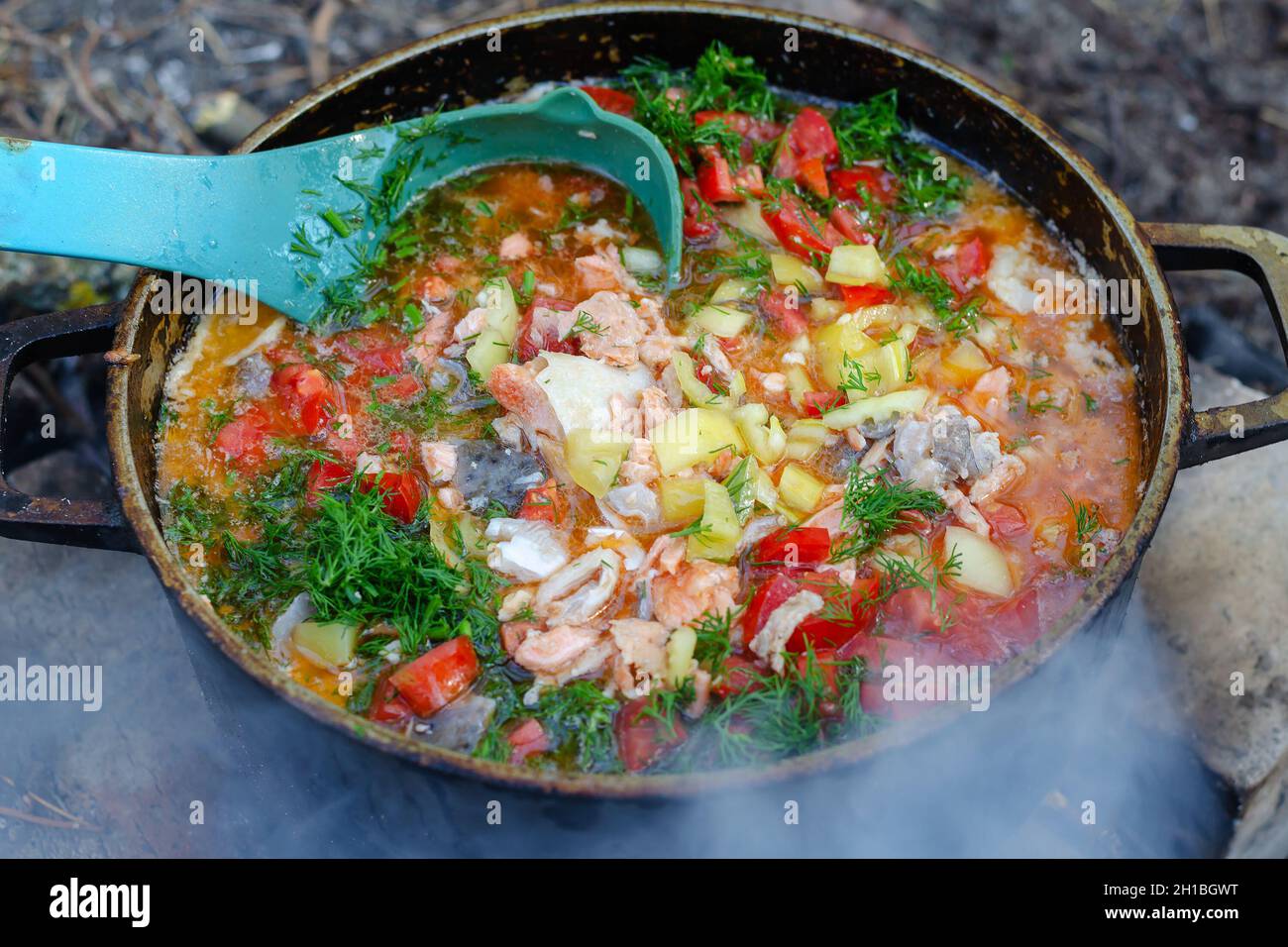Traditional fisherman's soup over a campfire. Ukha of fish and ...