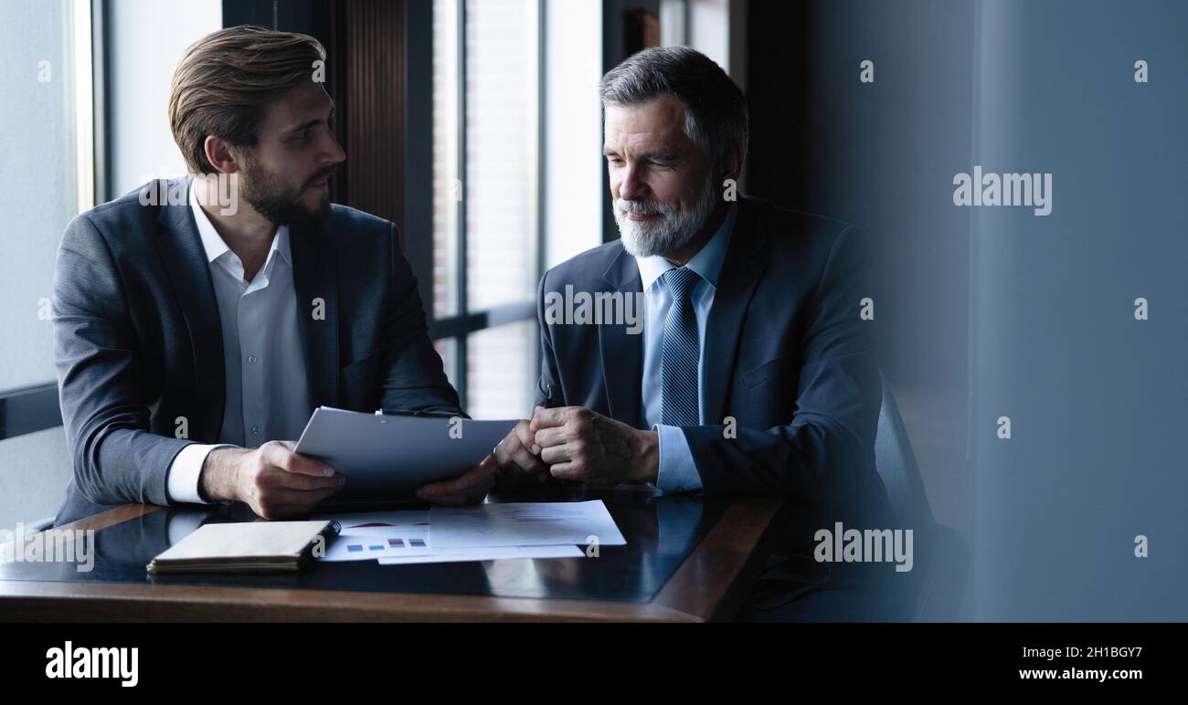 Senior and junior businessman discuss something during their meeting ...