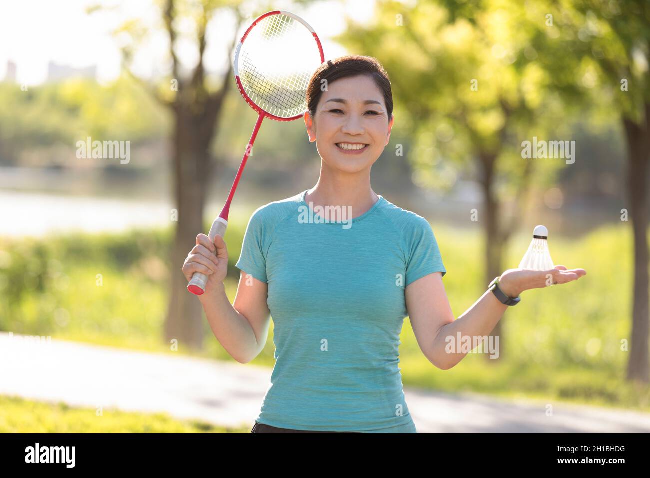 Happy mature woman playing badminton outdoors Stock Photo - Alamy