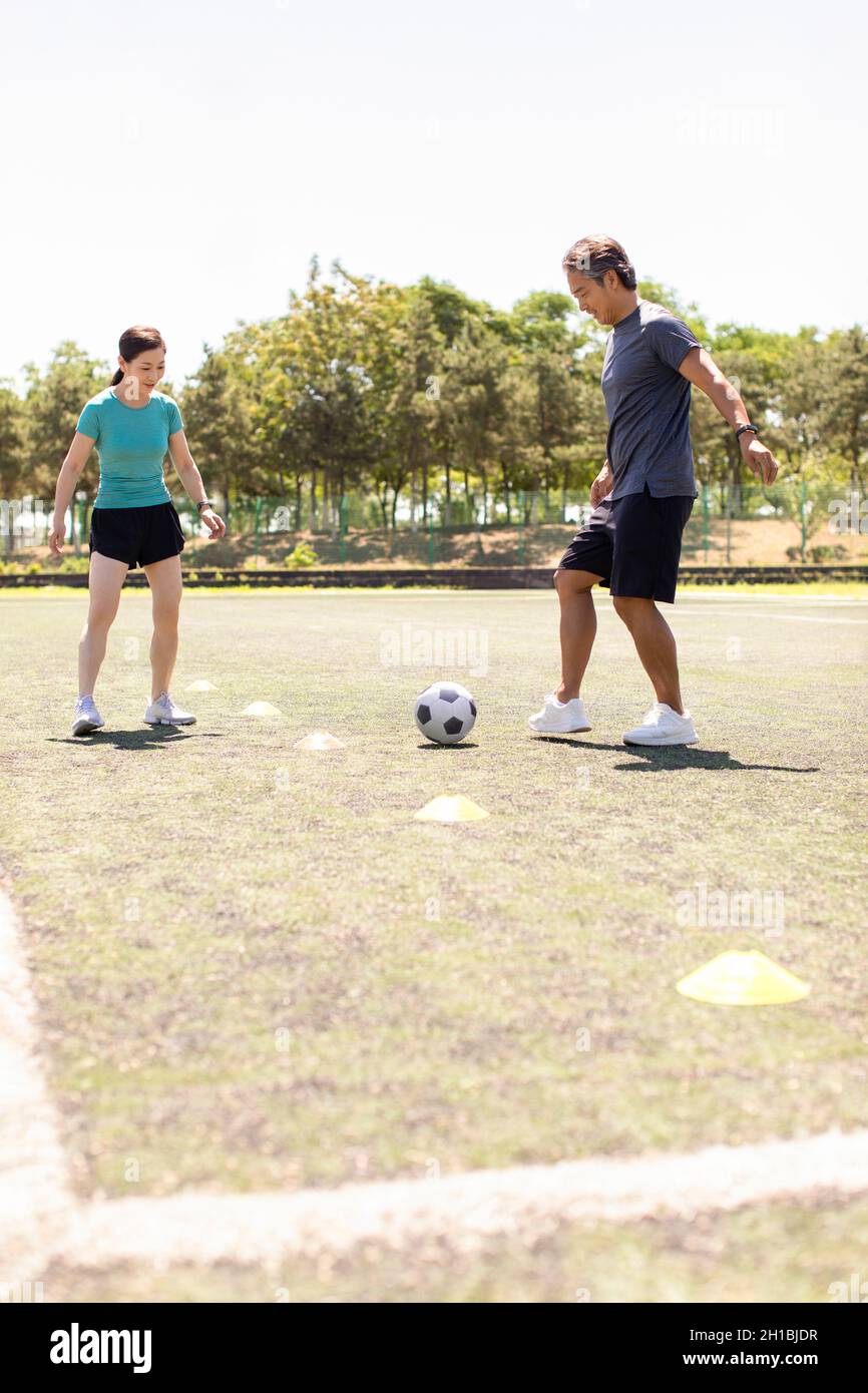 Happy mature couple playing football outdoors Stock Photo - Alamy