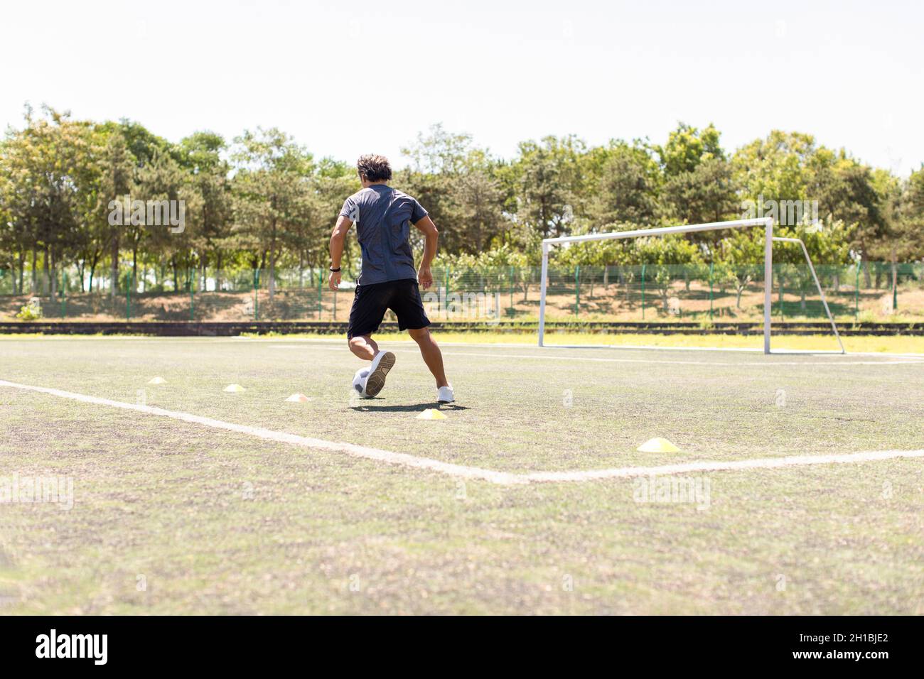 Mature man playing football outdoors Stock Photo - Alamy
