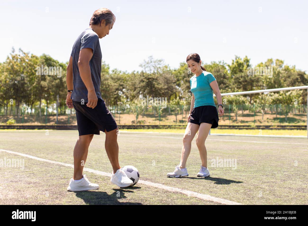 Happy mature couple playing football outdoors Stock Photo - Alamy