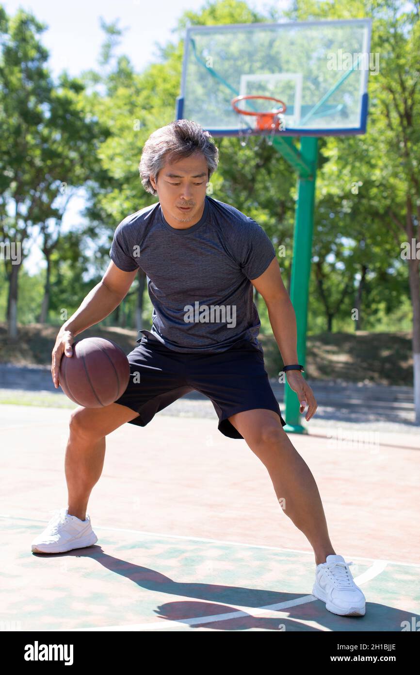 Mature man playing basketball outdoors Stock Photo - Alamy