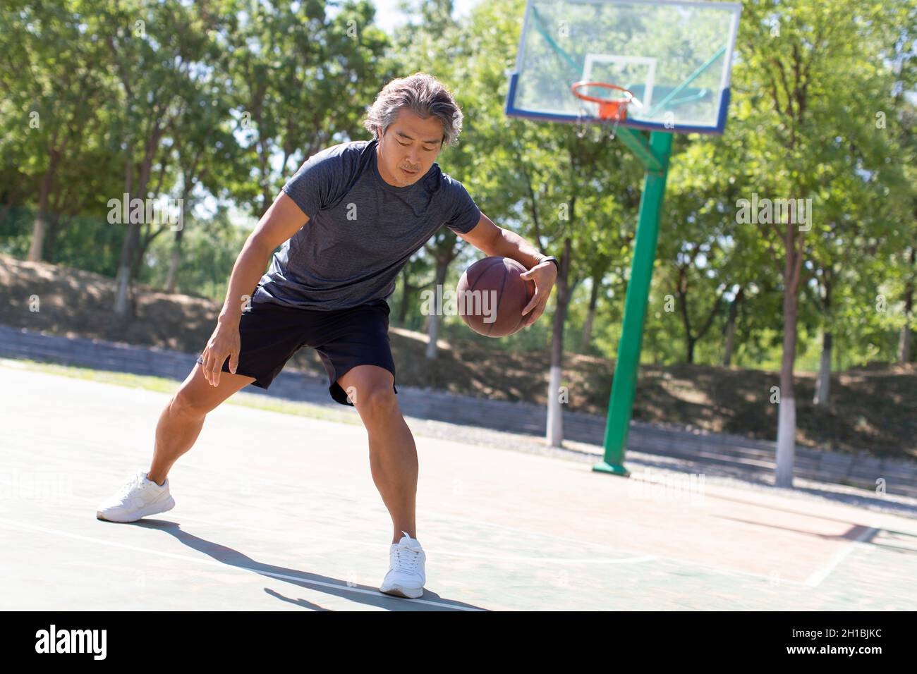 Mature man playing basketball outdoors Stock Photo - Alamy