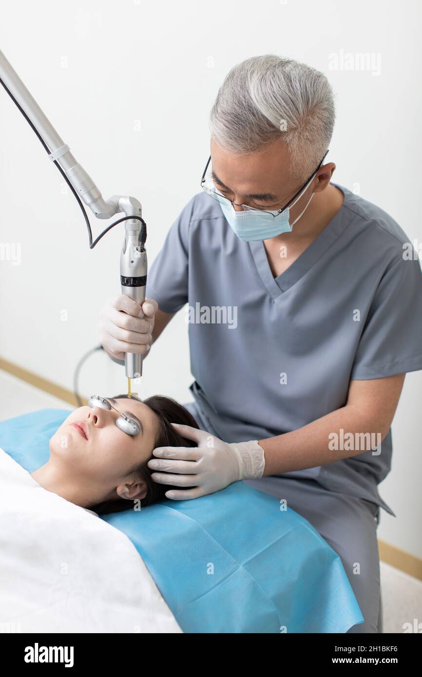 Young woman receiving face treatment in hospital Stock Photo - Alamy