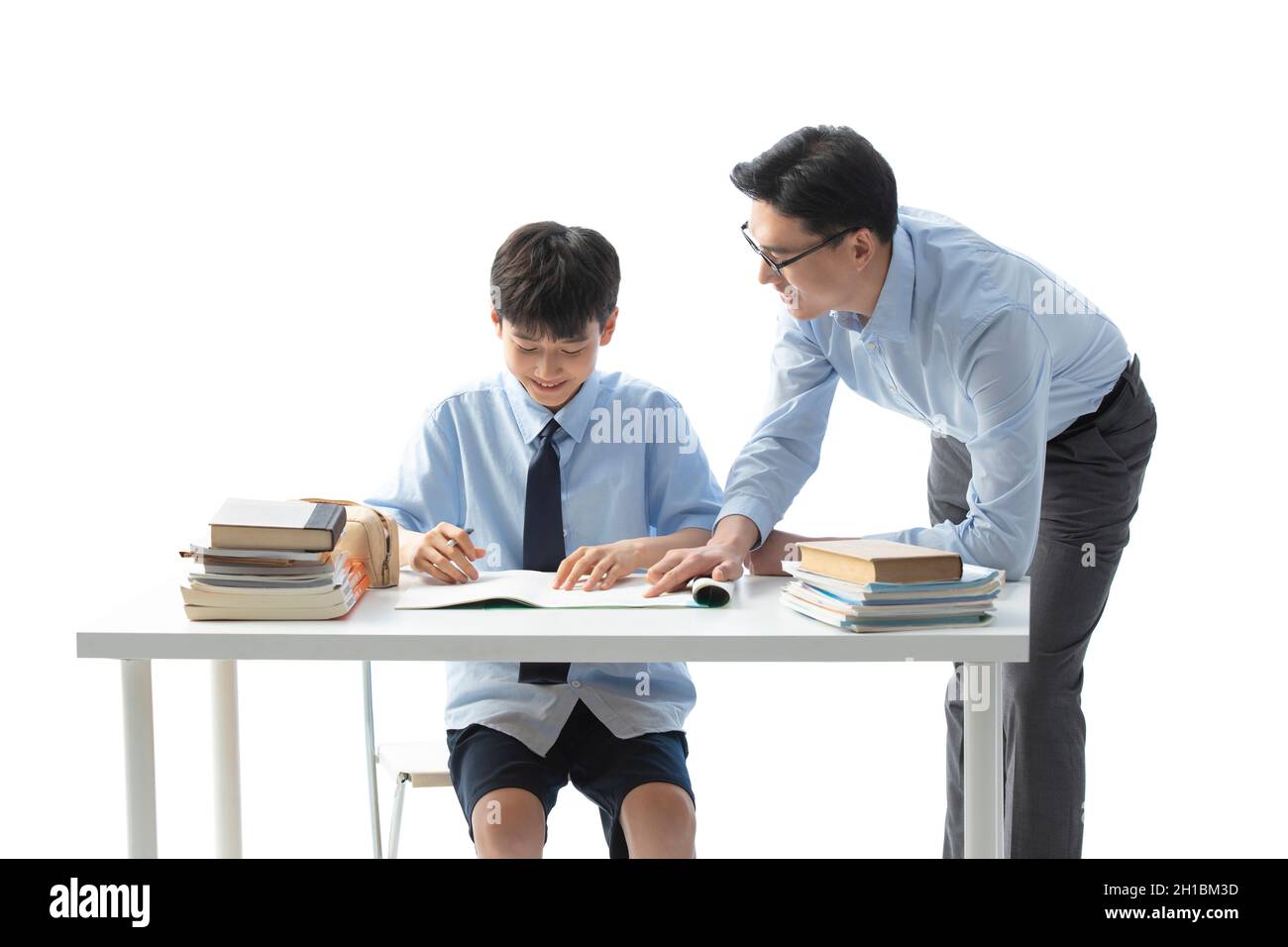 Teacher helping boy with homework Stock Photo - Alamy