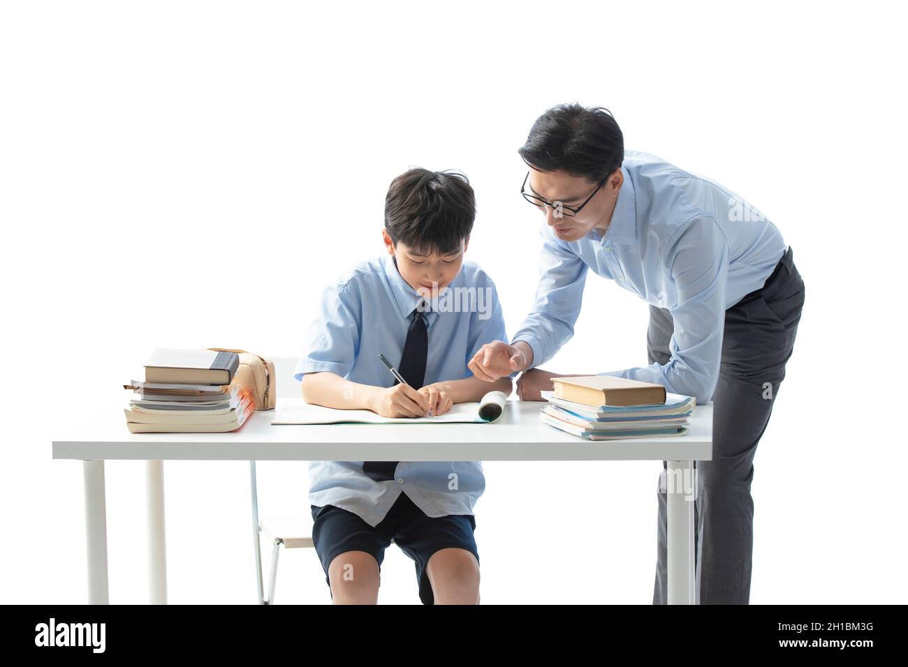 Teacher helping boy with homework Stock Photo - Alamy
