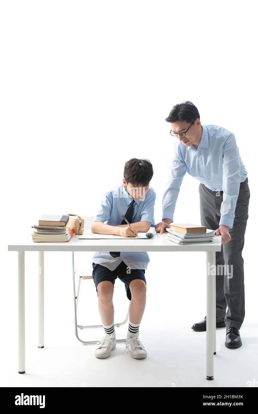 Teacher helping boy with homework Stock Photo - Alamy