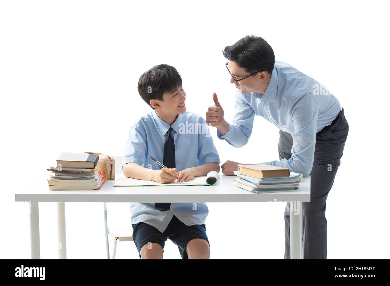 Teacher helping boy with homework Stock Photo - Alamy