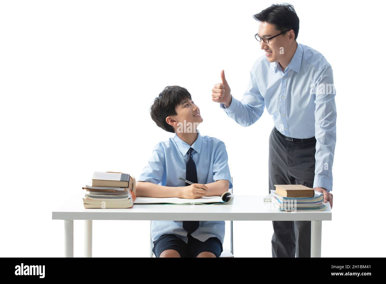 Teacher helping boy with homework Stock Photo - Alamy