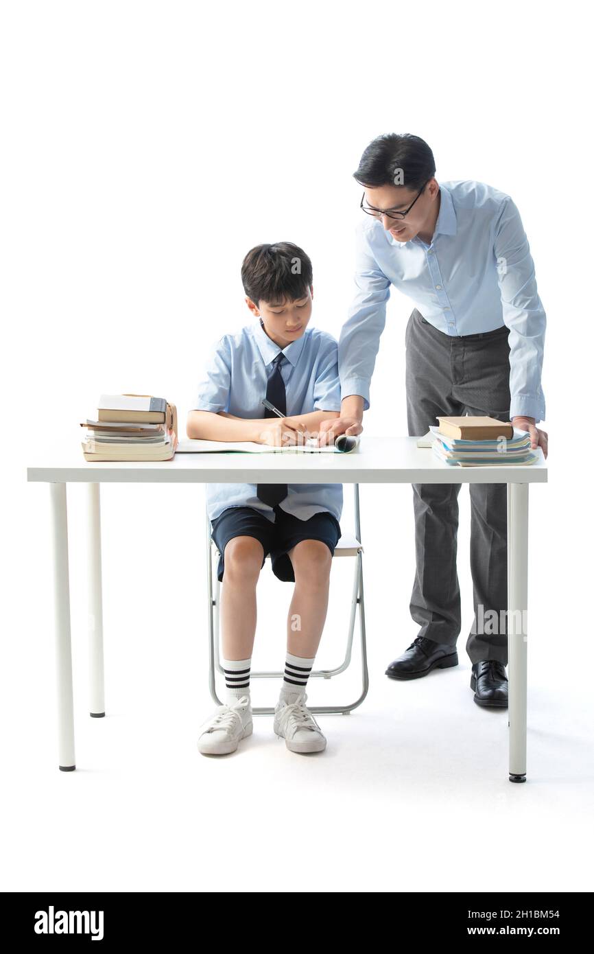 Teacher helping boy with homework Stock Photo - Alamy