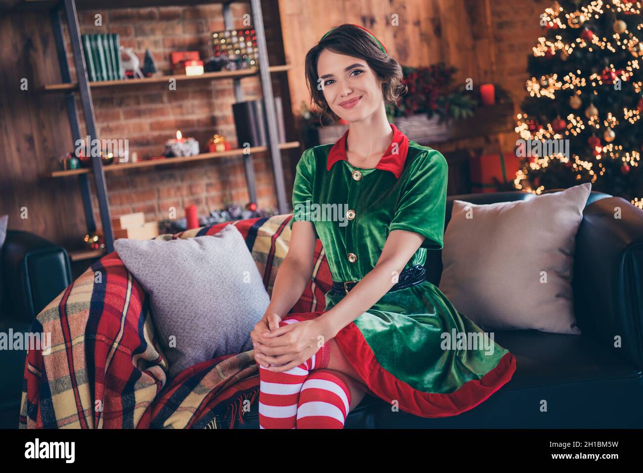 Portrait of attractive cheerful girl wearing elf look sitting on sofa ...