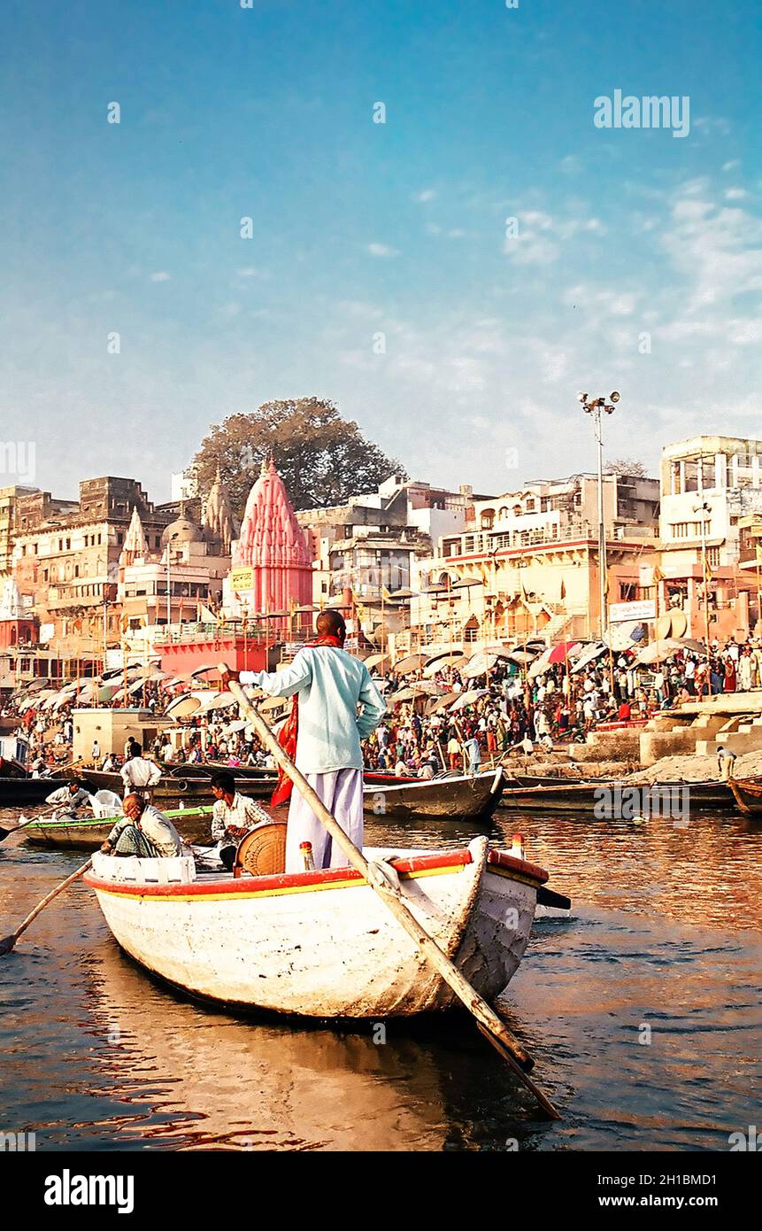 Boat at the sacred river Ganges near holy ghats with people in Varanasi ...