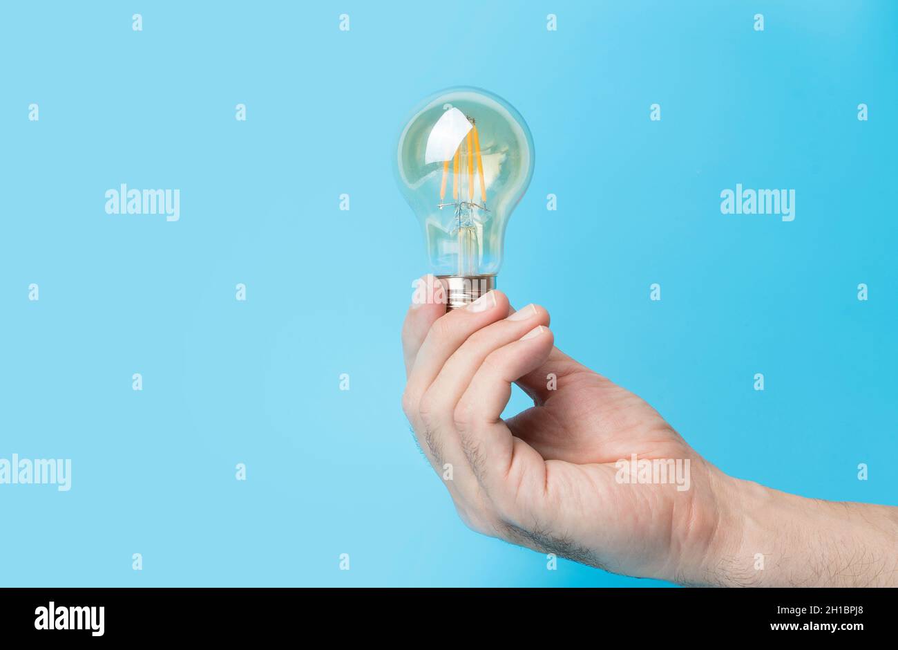 Knowledge and idea concept. Light bulb with light in hand on a blank ...