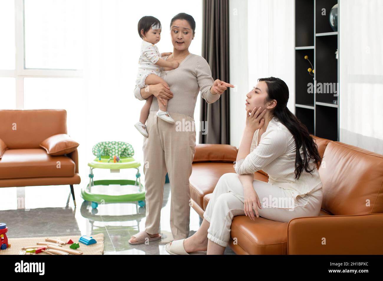 Baby's mother and grandmother arguing with each other Stock Photo - Alamy