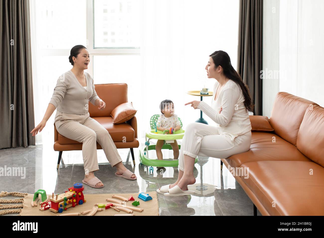 Baby's mother and grandmother arguing with each other Stock Photo - Alamy