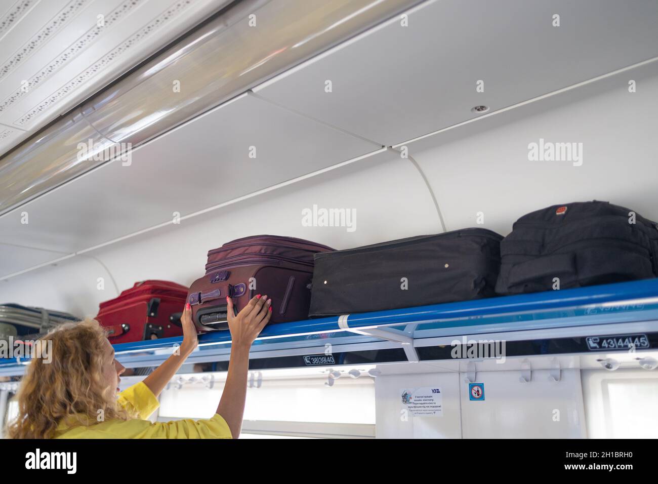 Female hands take off hand luggage. Young woman putting the baggage on ...