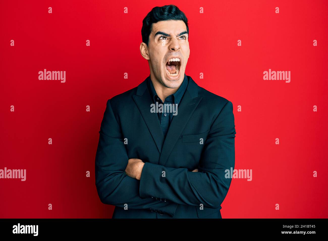Handsome hispanic business man with arms crossed gesture angry and mad ...
