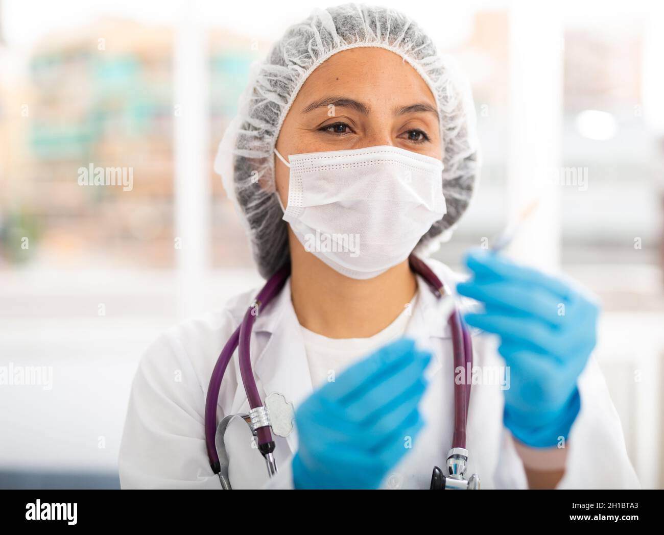 Female health worker prepares a syringe for injection in the treatment ...