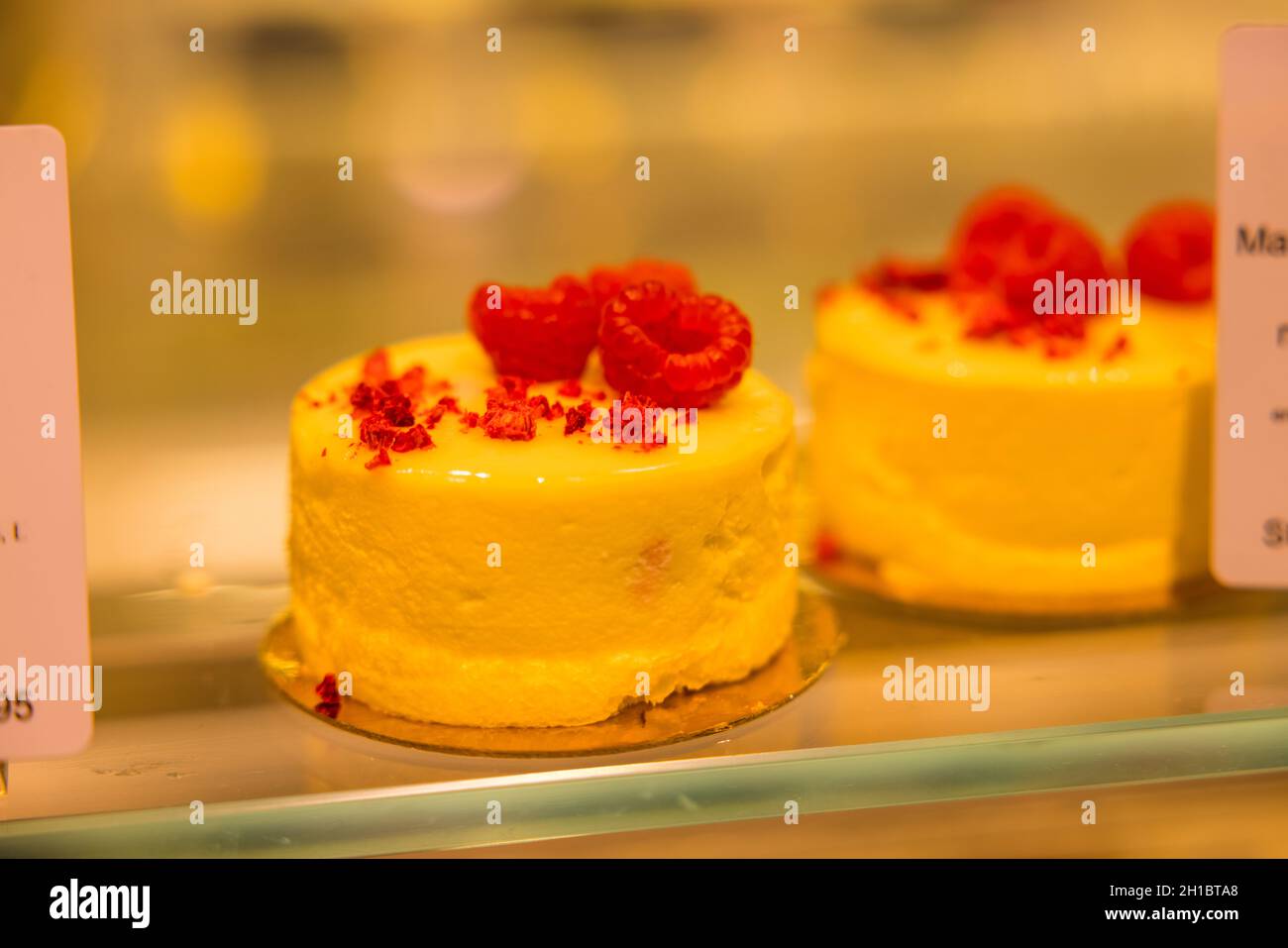 Delicious glazed cakes with fresh raspberries in the bakery Stock Photo ...