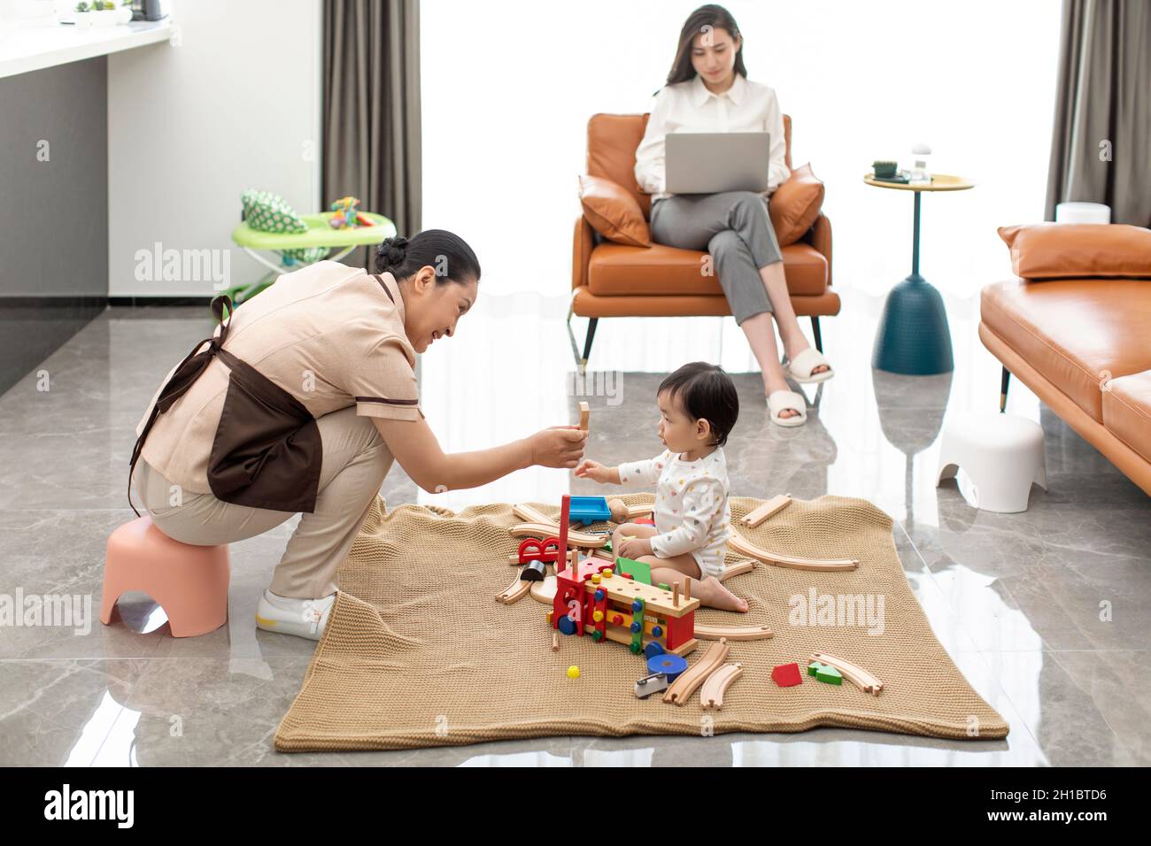 Nanny taking care of baby girl Stock Photo - Alamy