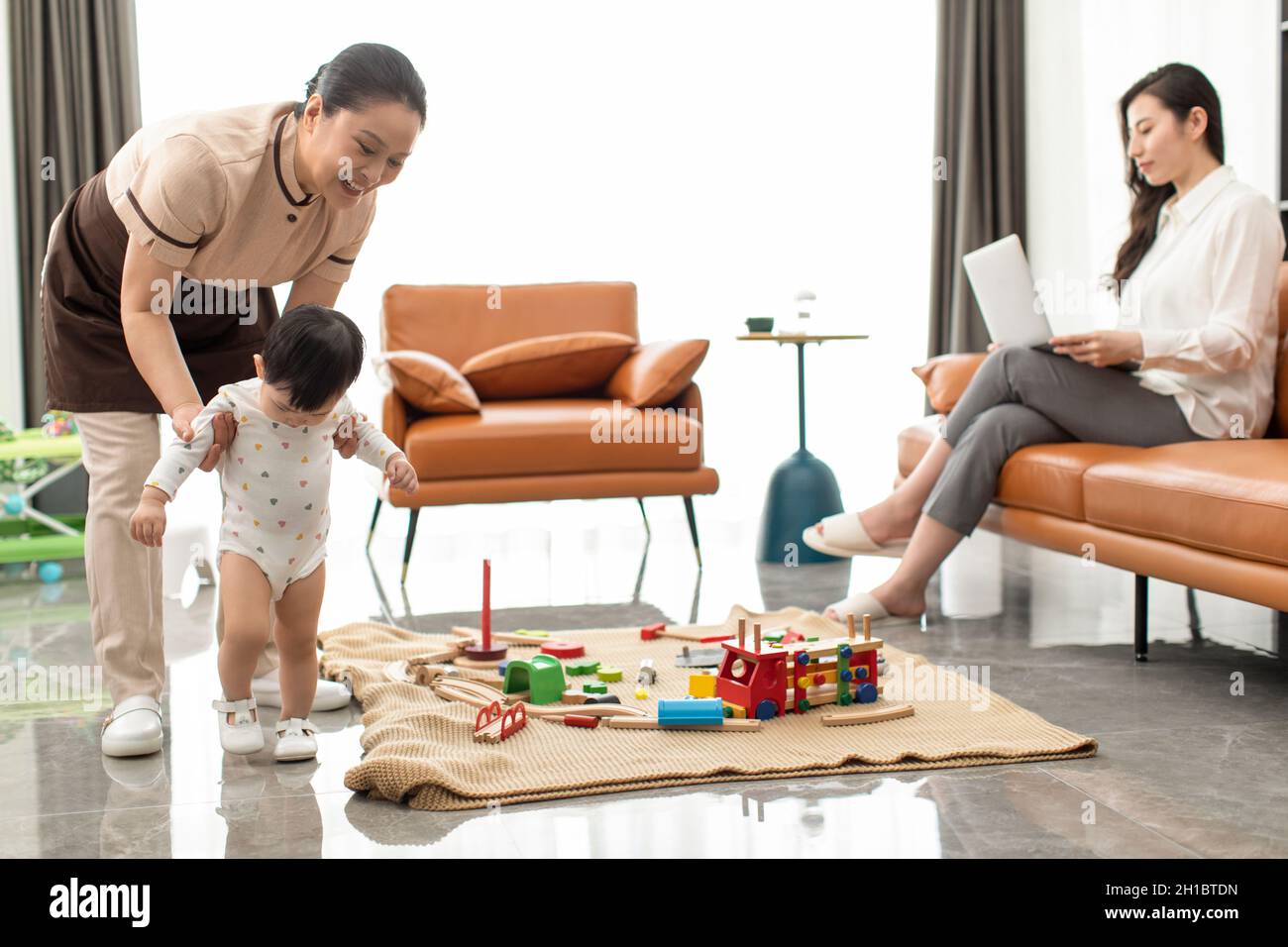 Nanny taking care of baby girl Stock Photo - Alamy