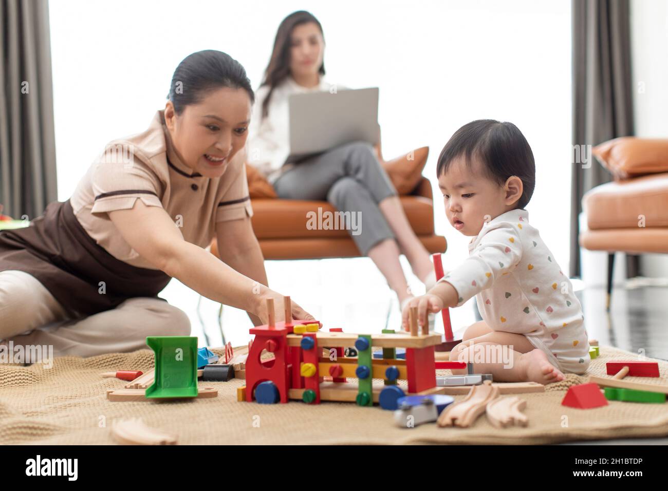 Nanny taking care of baby girl Stock Photo - Alamy