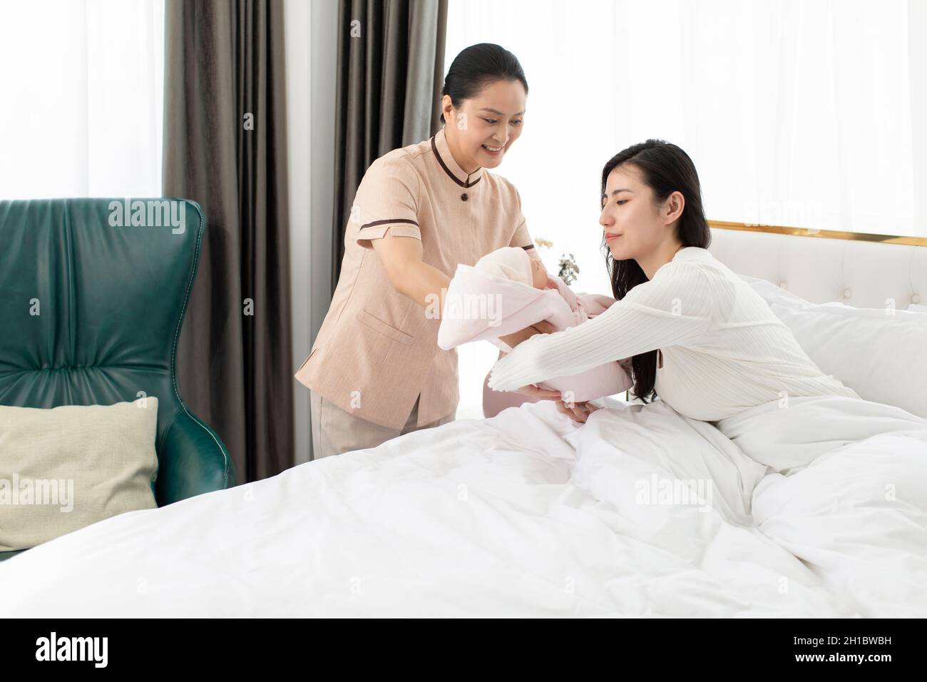 Confinement nurse taking care of young mother and baby Stock Photo - Alamy
